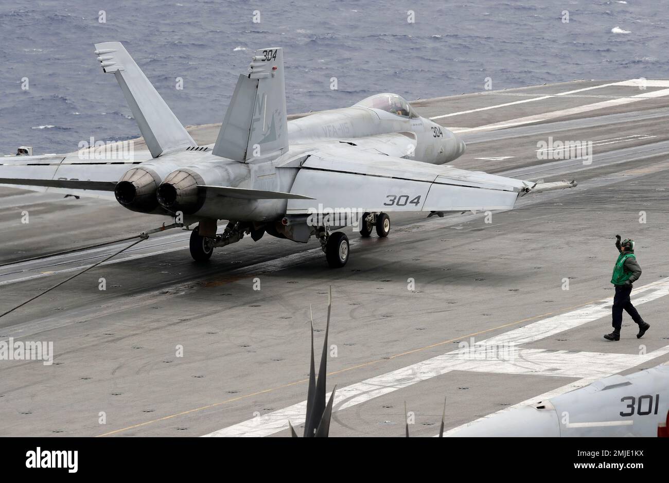A U.S. fighter jet lands on the U.S. aircraft carrier USS Ronald Reagan ...