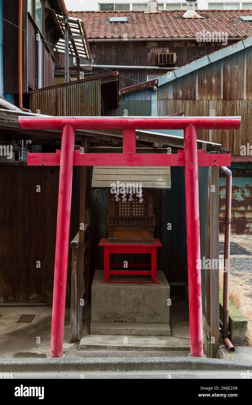 A small roadside shinto shrine with a red torii gate in Tokyo, Japan ...