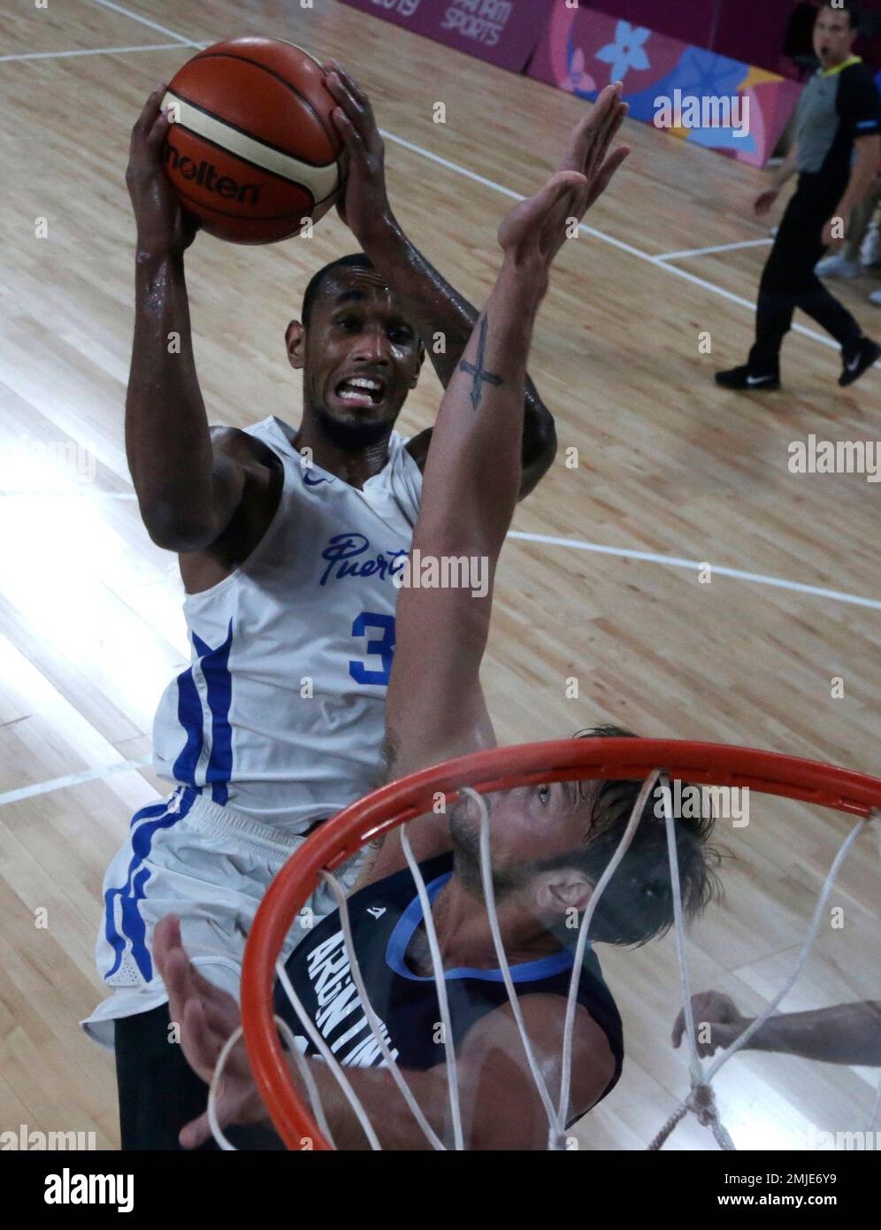 Derek Reese of Puerto Rico, top, shoots over Marcos Delia of Argentina ...