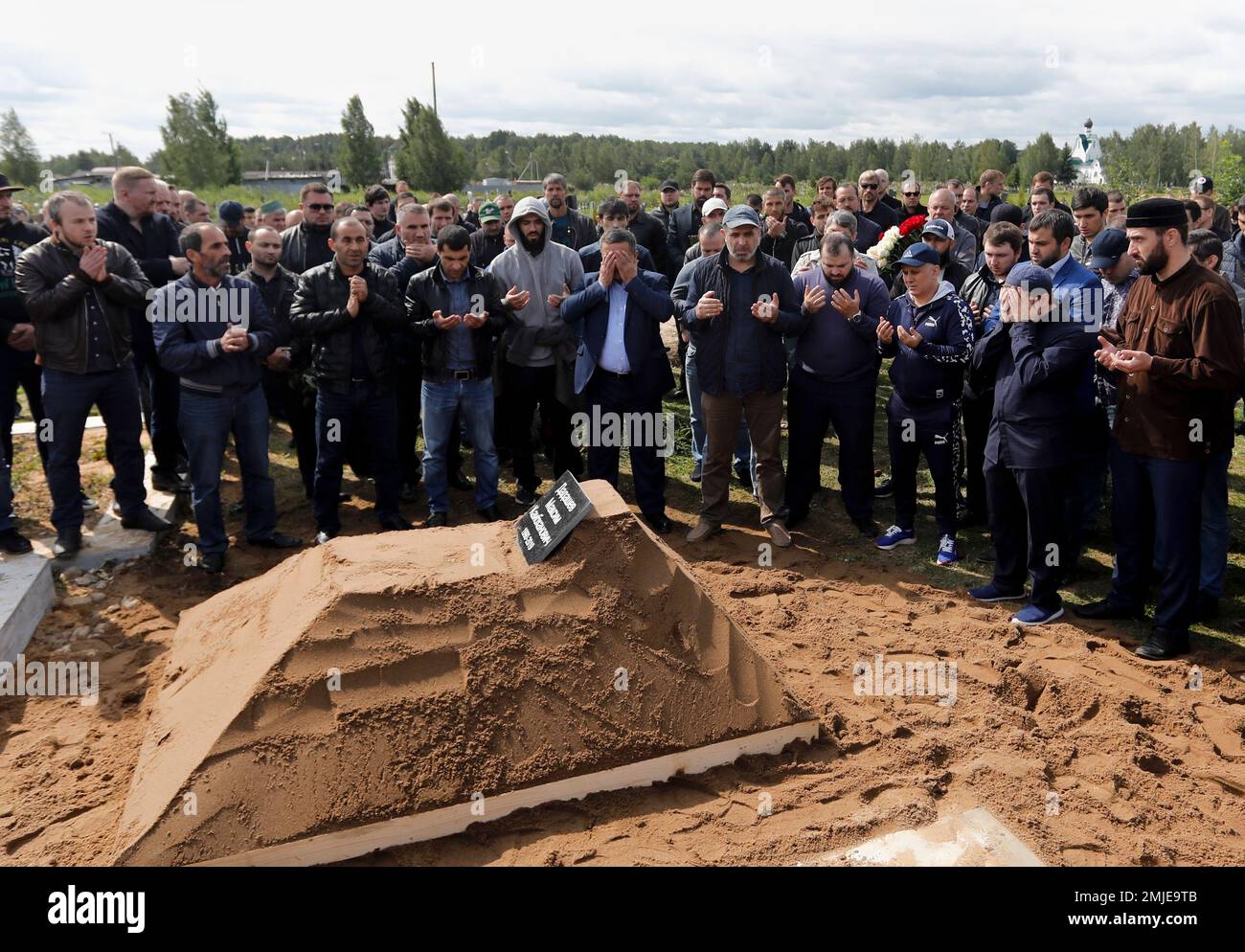 People pray at the grave of Russian boxer Maxim Dadashev, who died after suffering a brain ...