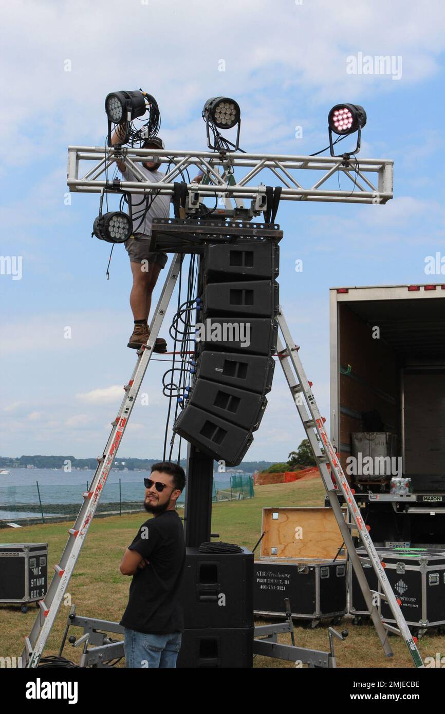Lighting and sound technicians assemble and check speakers and lighting ...