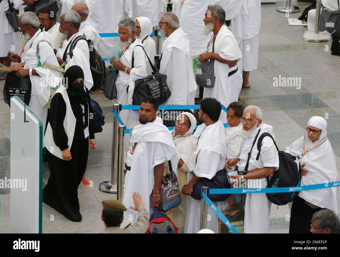Pilgrims line up as they wait to stamp their passports at the Hajj ...