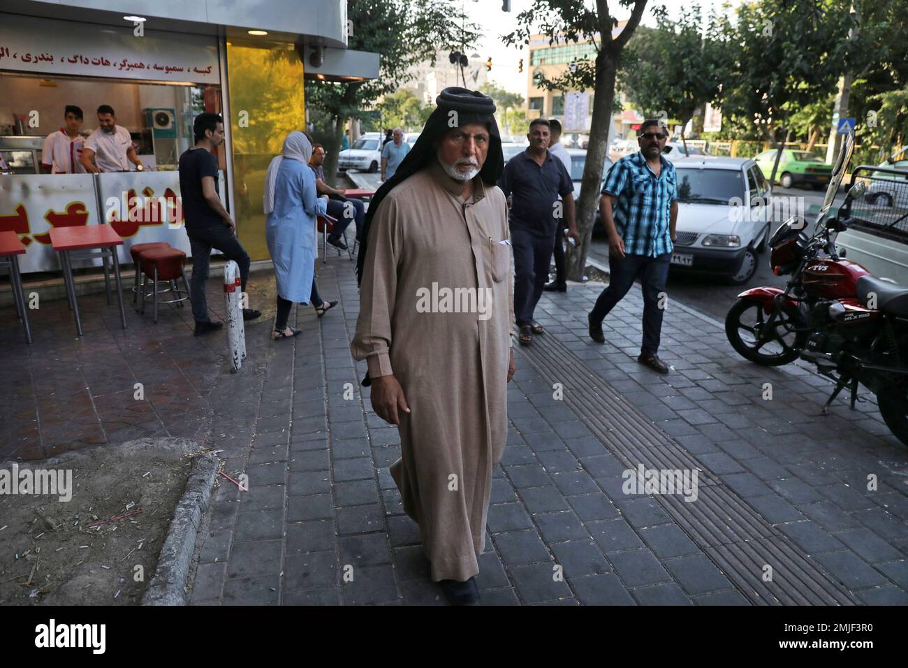 An Iraqi man walks on a sidewalk in a predominantly Iraqi neighborhood ...
