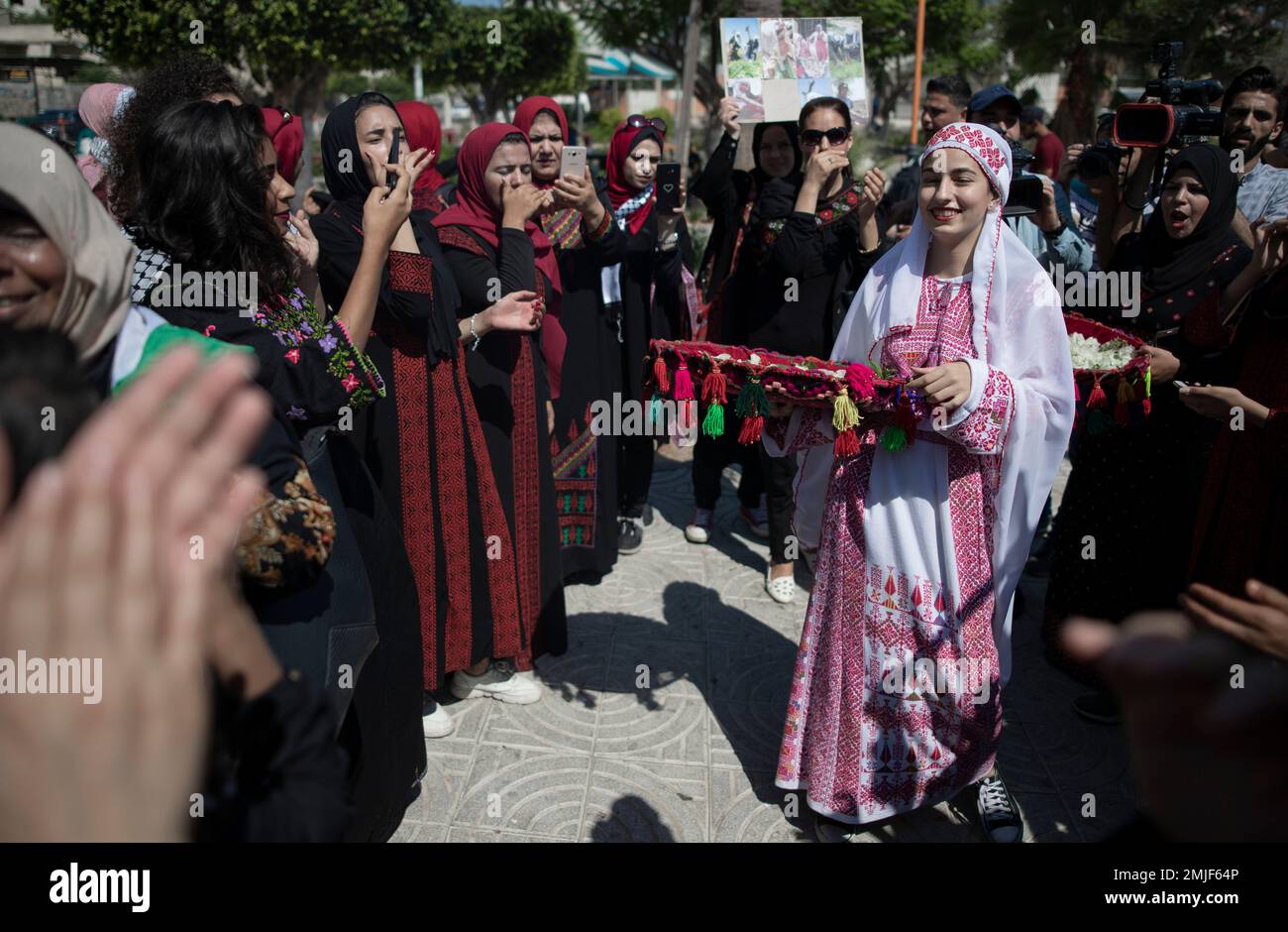 Palestinians wear traditional dresses as they demonstrate marking the ...