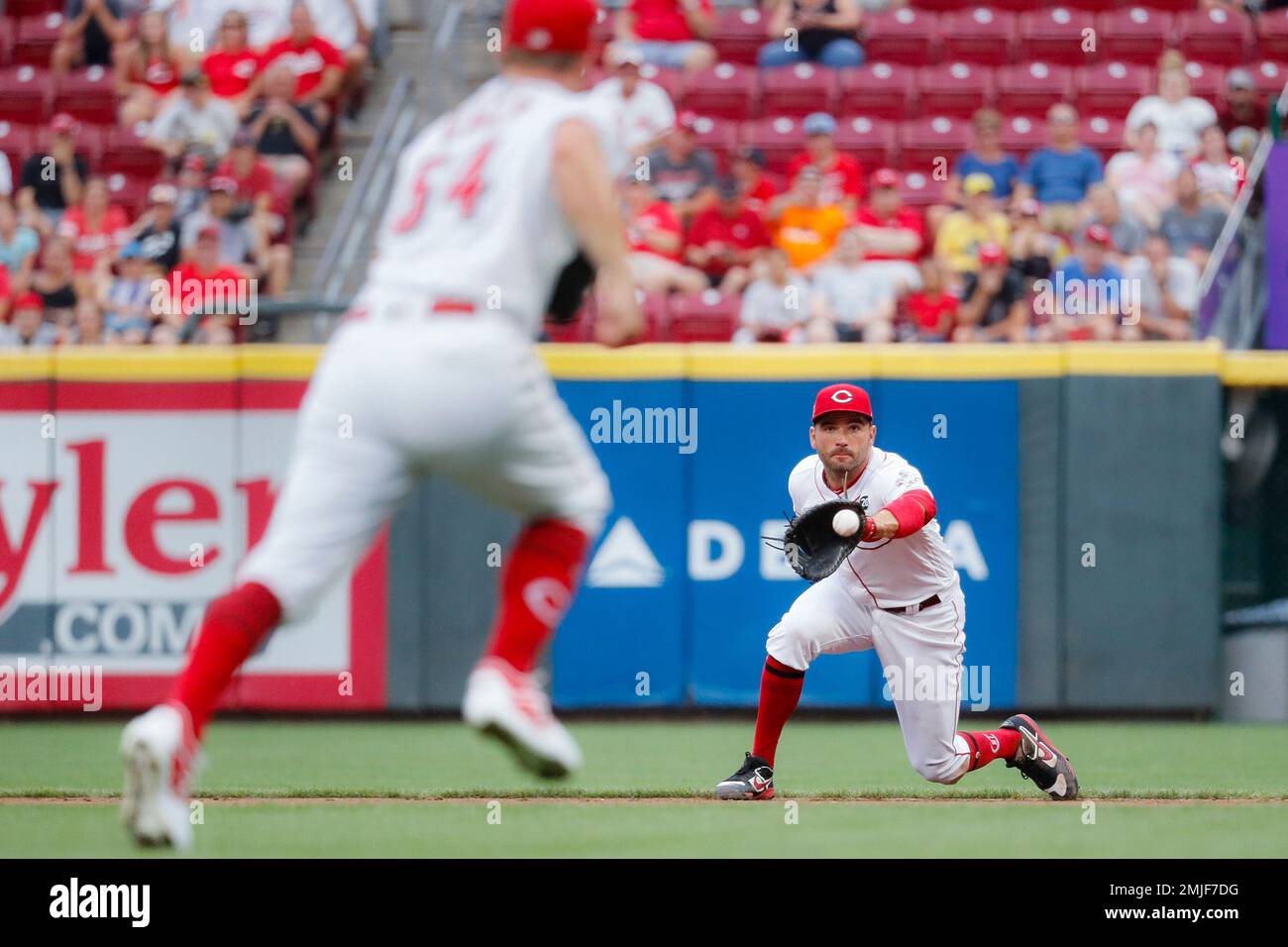 Cincinnati Reds first baseman Joey Votto, right, fields a ground ball ...