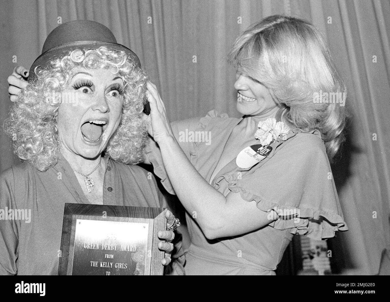 Comedian Phyllis Diller, wearing a wig of bright green hair, receives ...