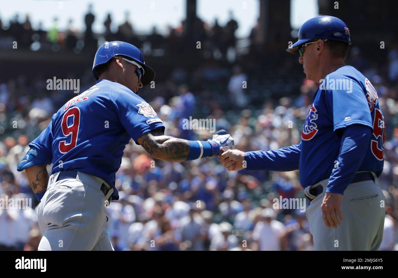 Chicago Cubs' Javier Baez, left, is congratulated by third base coach ...
