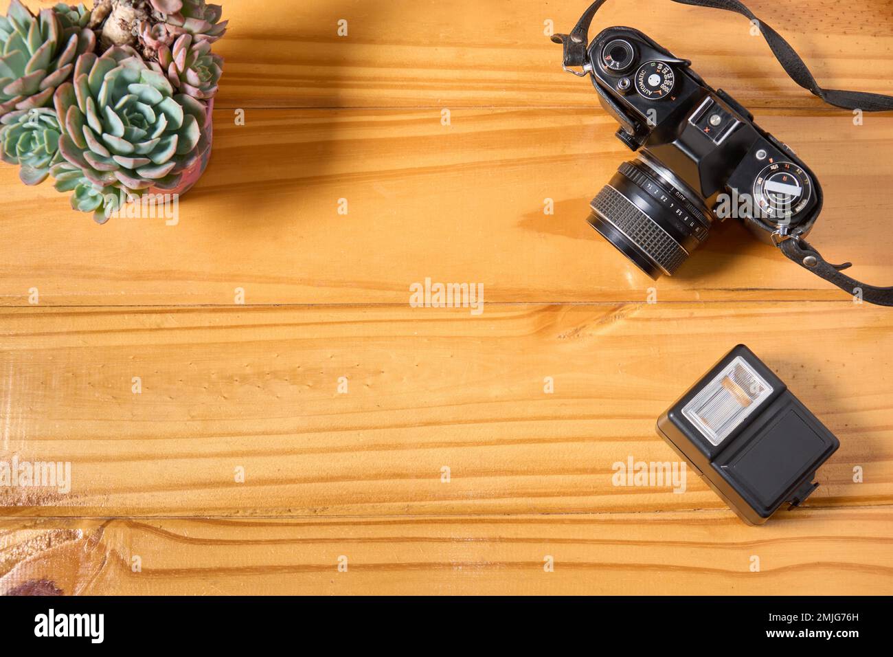 Top view of analog camera and flash on wooden table, professional ...