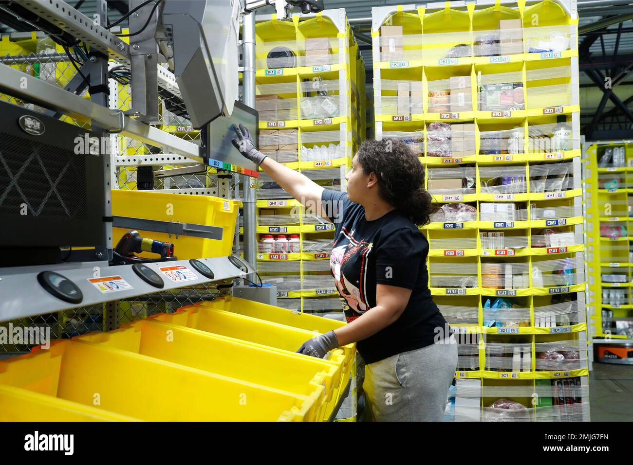 A worker sorts through items and places orders using storage units ...