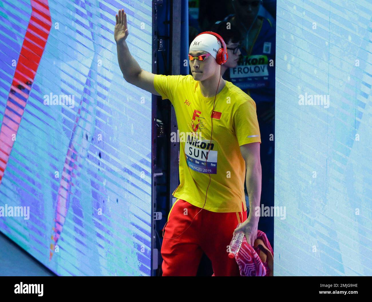 China's Sun Yang waves as he arrives on the pool deck for the men's ...