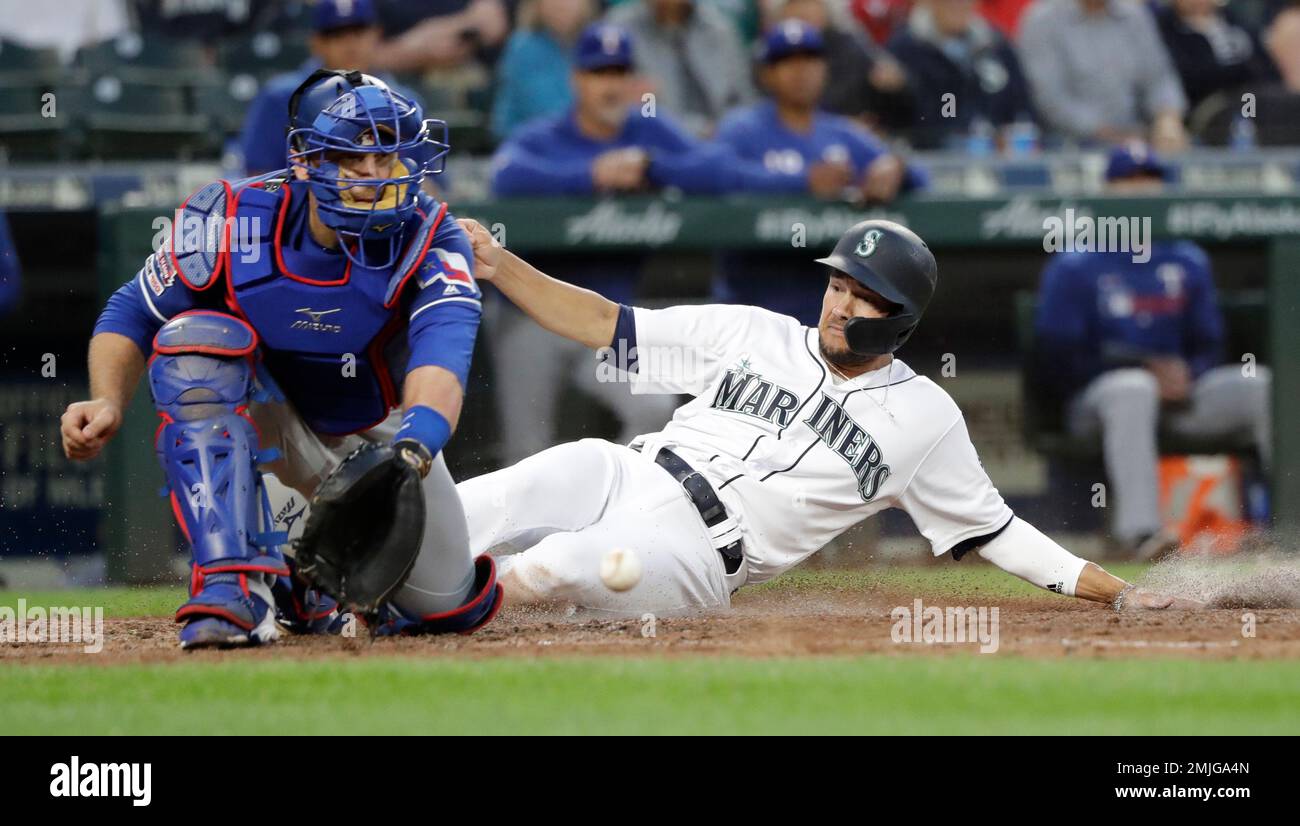 Seattle Mariners' Kristopher Negron, right, scores as Texas Rangers ...