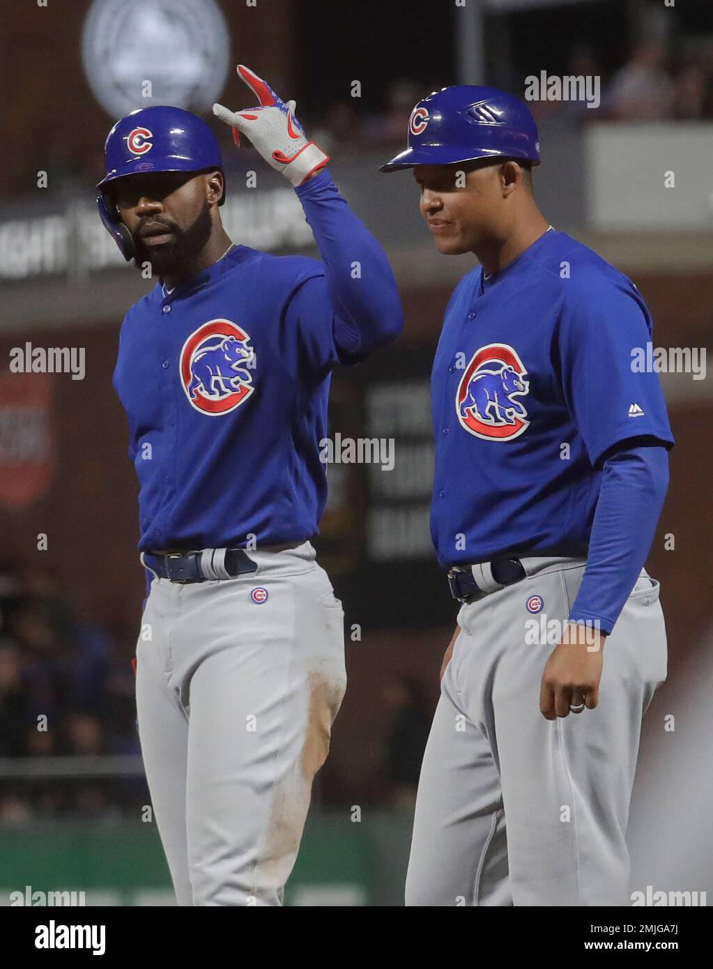 Chicago Cubs' Jason Heyward, left, gestures next to first base coach ...