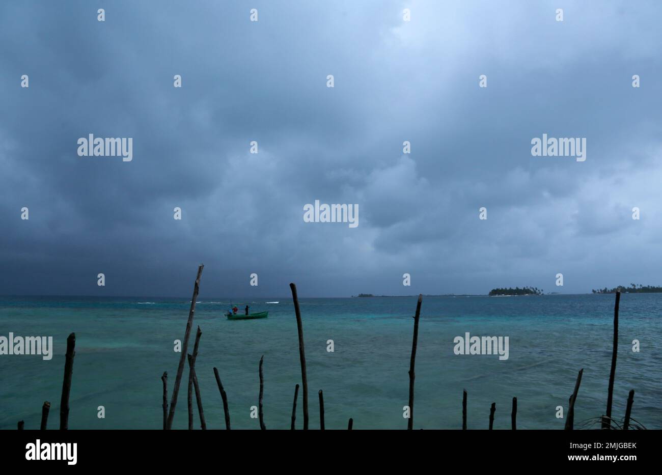 Men of the Guna indigenous group lay a fishing net before a rain storm ...