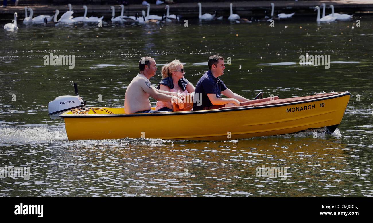People enjoy a boat ride along the River Thames in Windsor, England ...