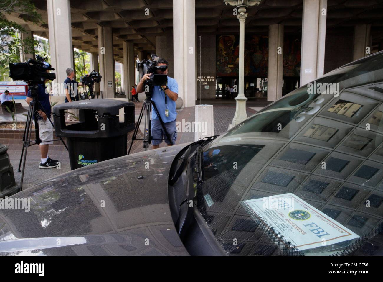 Members of the media record a van with an FBI placard inside that was ...
