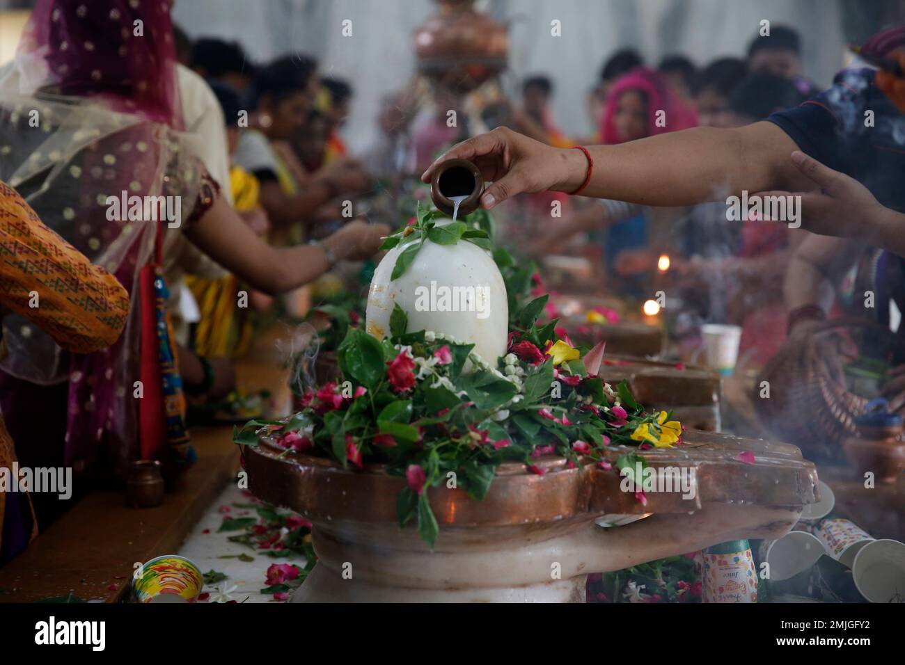 Hindu devotees offer prayers to a row of Shivlings, idols symbolic of ...