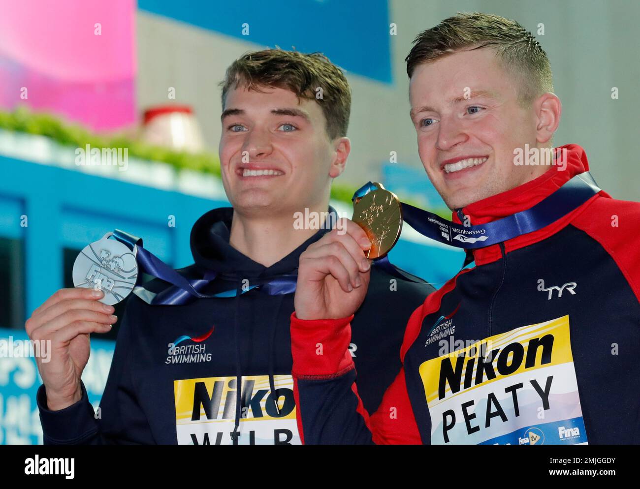 Gold medalist Britain's Adam Peaty, right, holds up his medal with ...