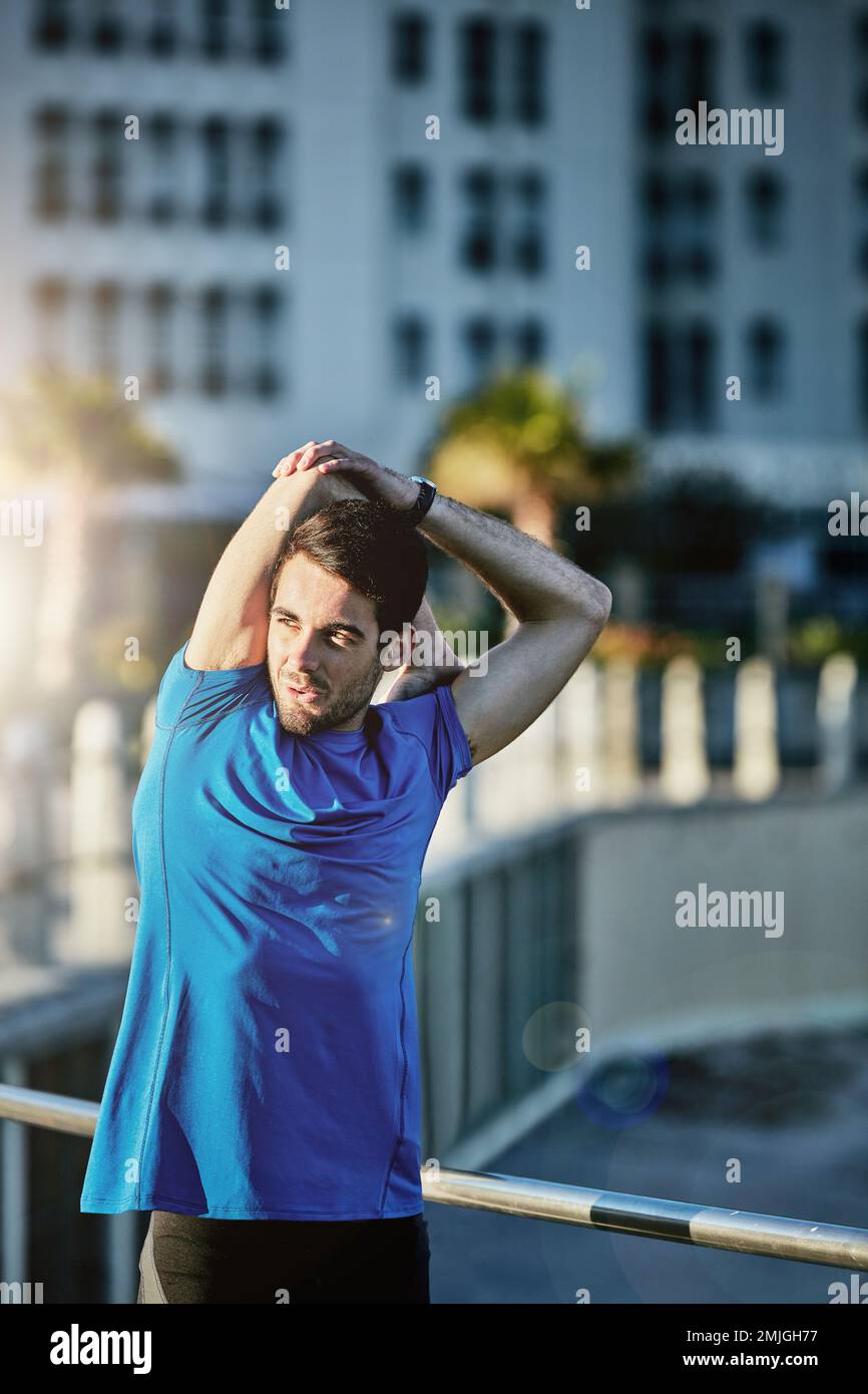 Keep the body loose and limber. a young man stretching outside before ...