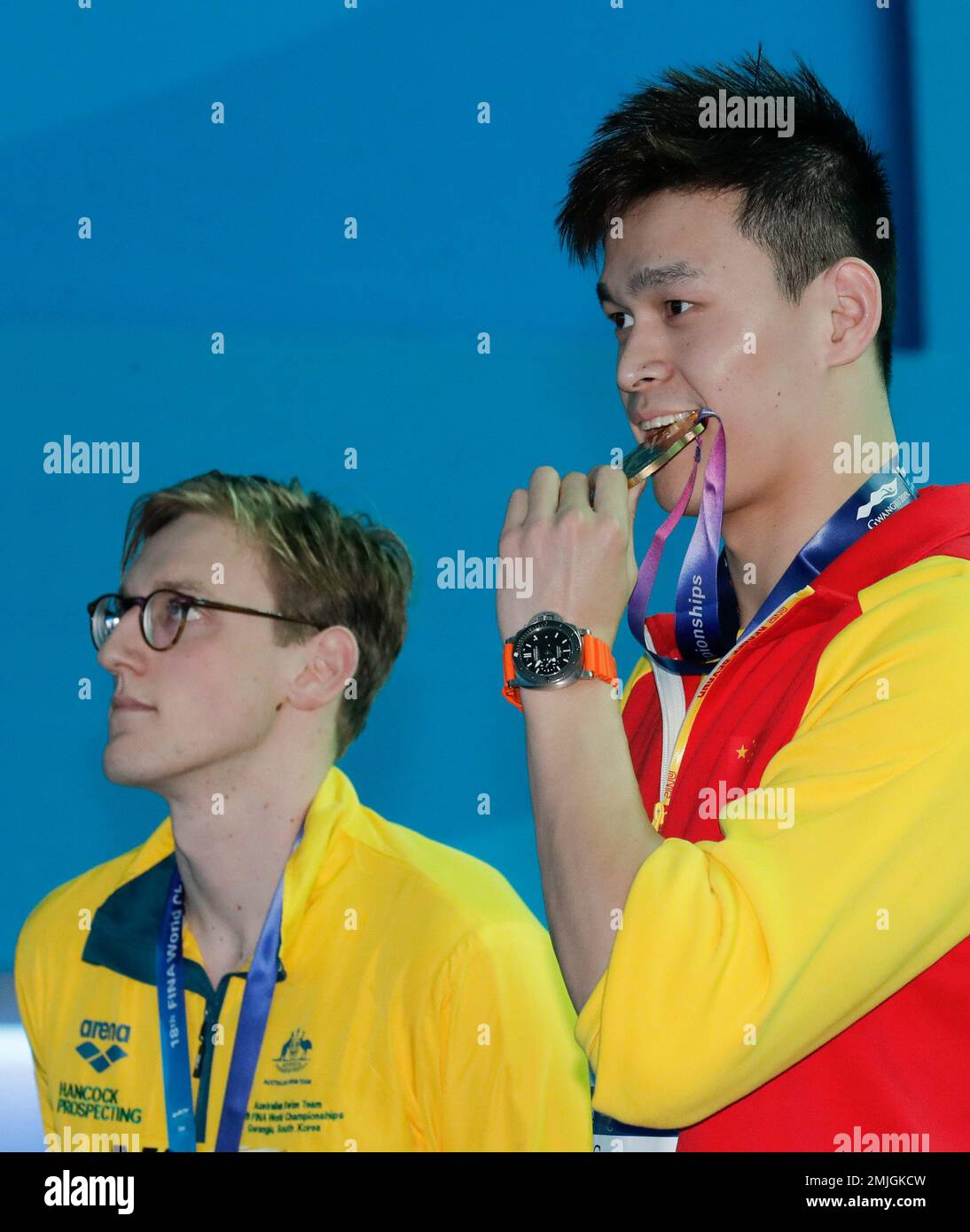 China's Sun Yang, right, bites his gold medal with silver medalist ...