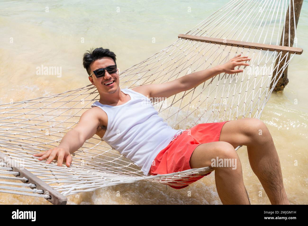 Man sitting hammock beach hi-res stock photography and images - Alamy