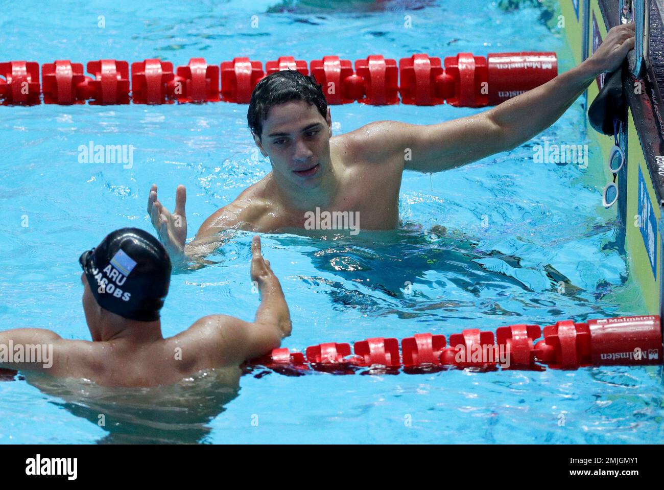 Syria's Omar Abbas, right, shakes hands with Aruba's Daniel Jacobs following their men's 400m ...