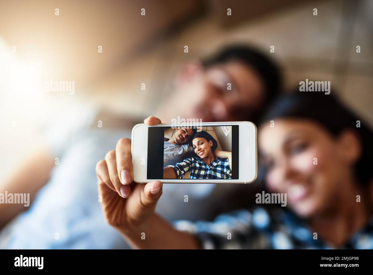 New beginnings. a happy young couple taking a selfie while lying on the ...
