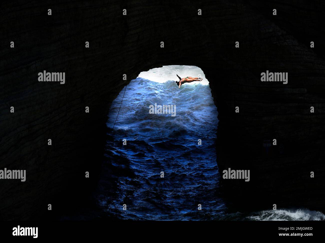 A cliff diver jumps from the landmark Raouche sea rock, during ...