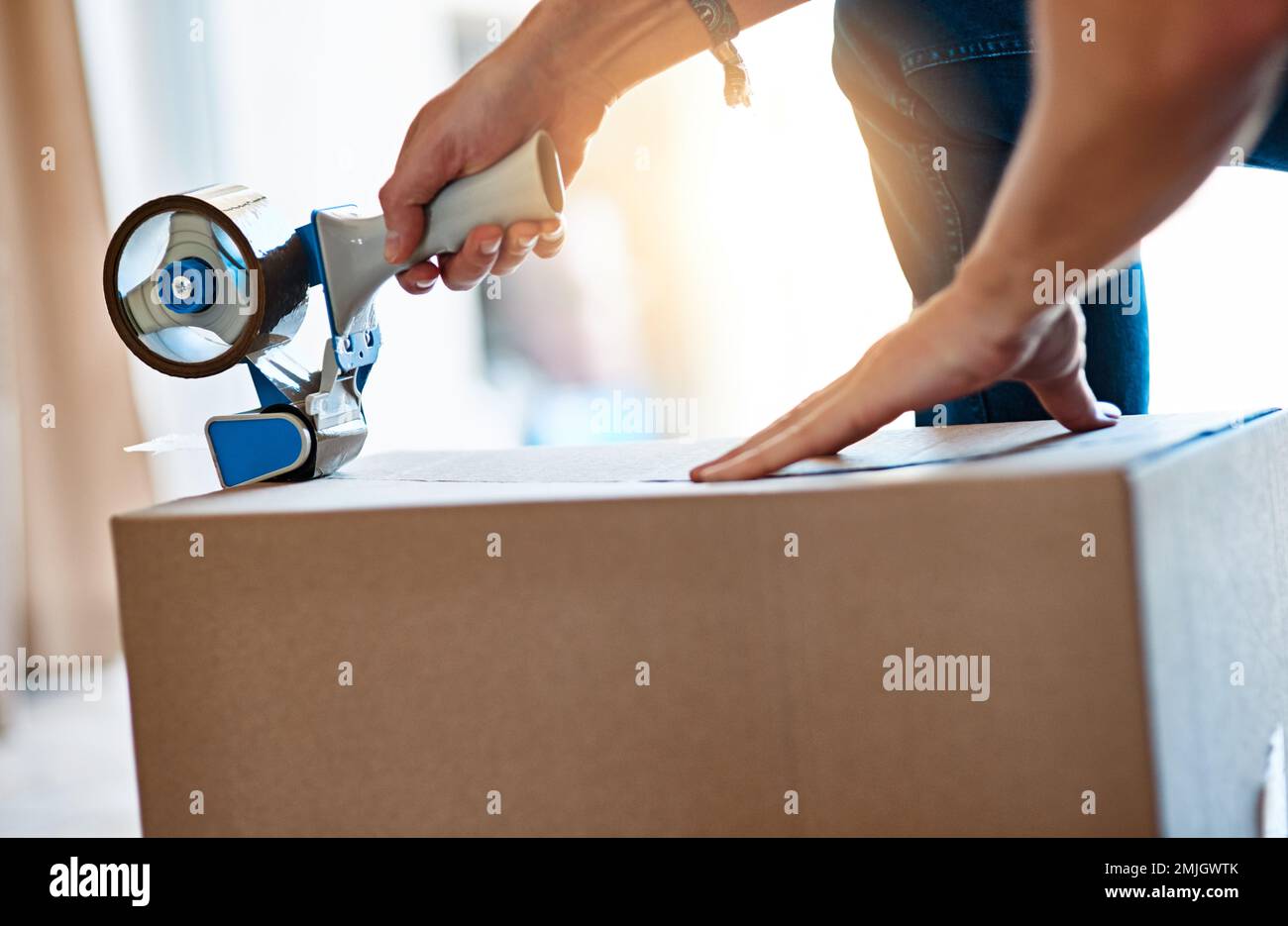 Wrap it, pack it, tape it. an unrecognizable young man closing a ...