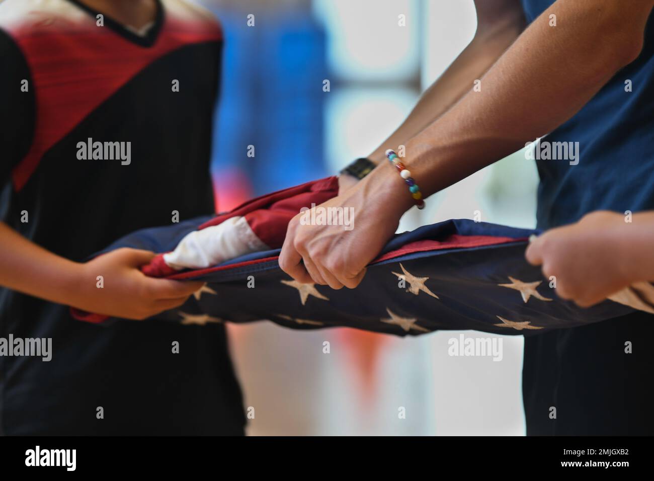 A Junior ROTC cadet helps Kadena Elementary School students fold the ...