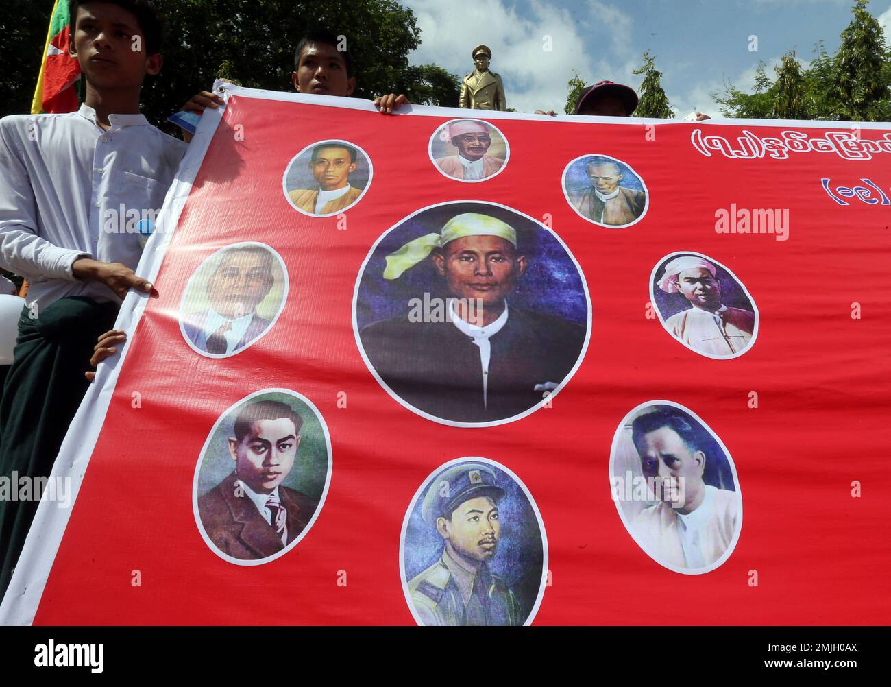 People hold a picture of Gen. Aung San, center, and other leaders ...