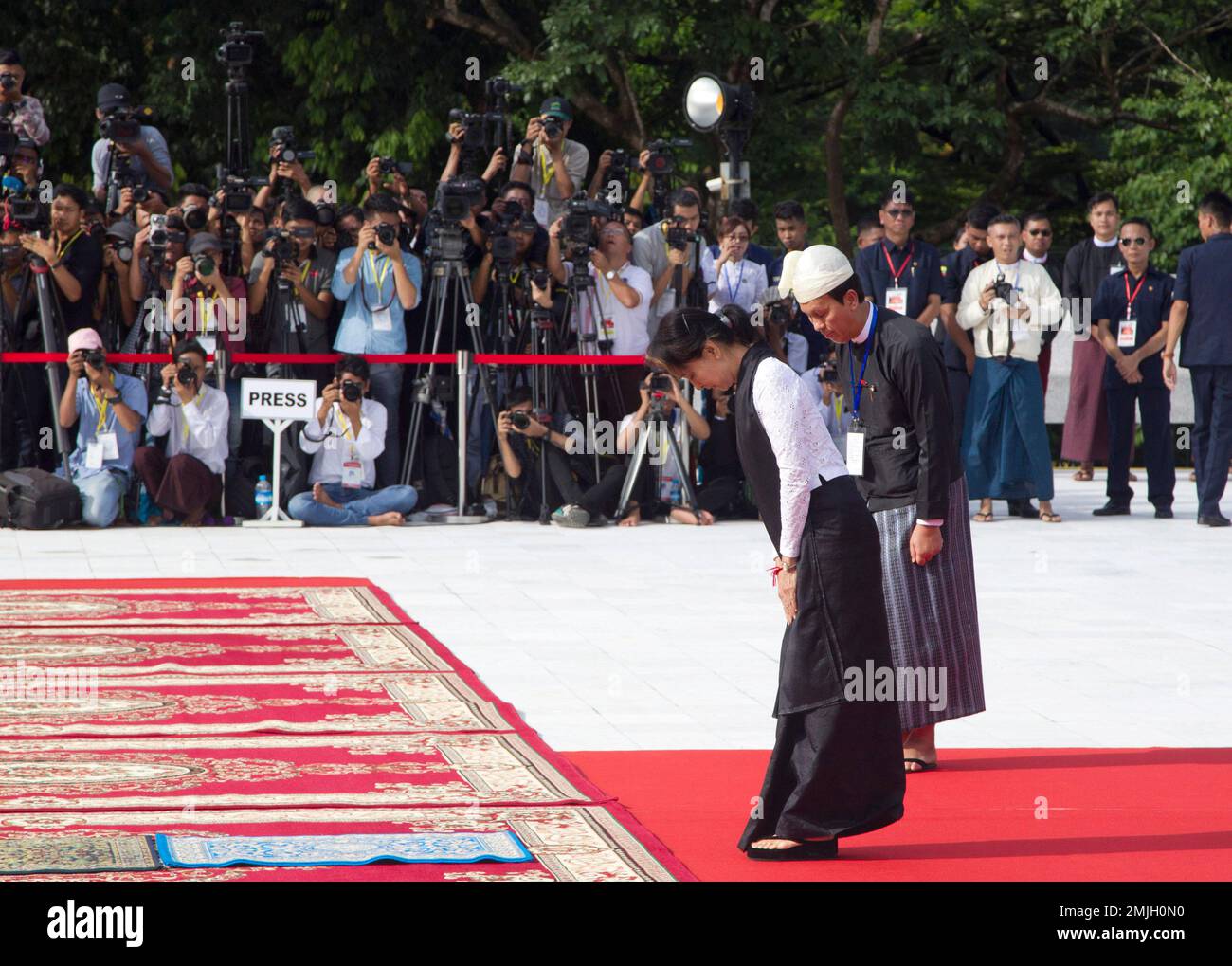 Myanmar leader Aung San Suu Kyi, foreground, salutes at the tomb of her ...