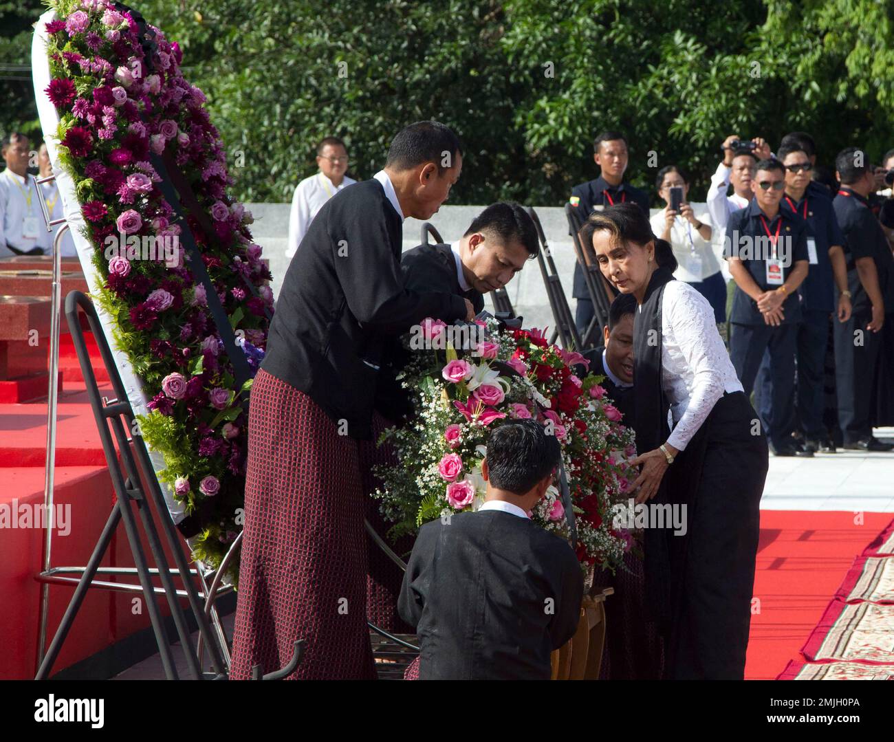 Myanmar leader Aung San Suu Kyi, right, lays flower basket at the tomb ...