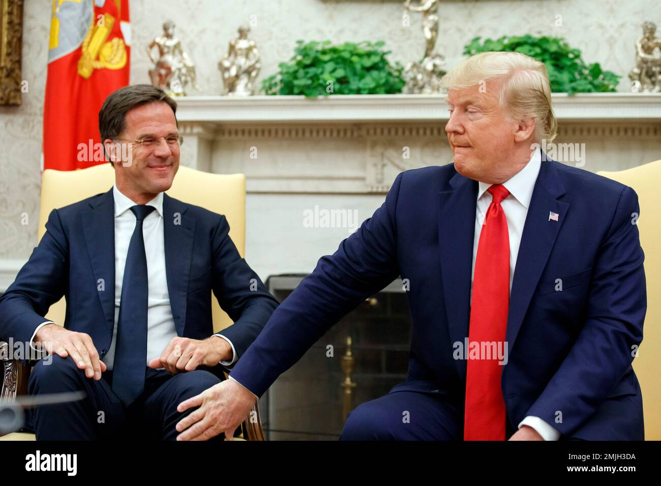 President Donald Trump taps Dutch Prime Minister Mark Rutte on his knee ...