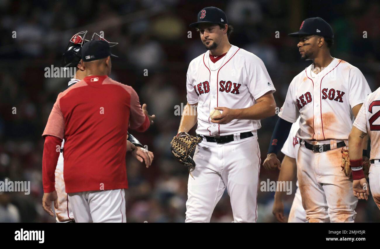 Boston Red Sox manager Alex Cora, left, reaches to take the ball from ...