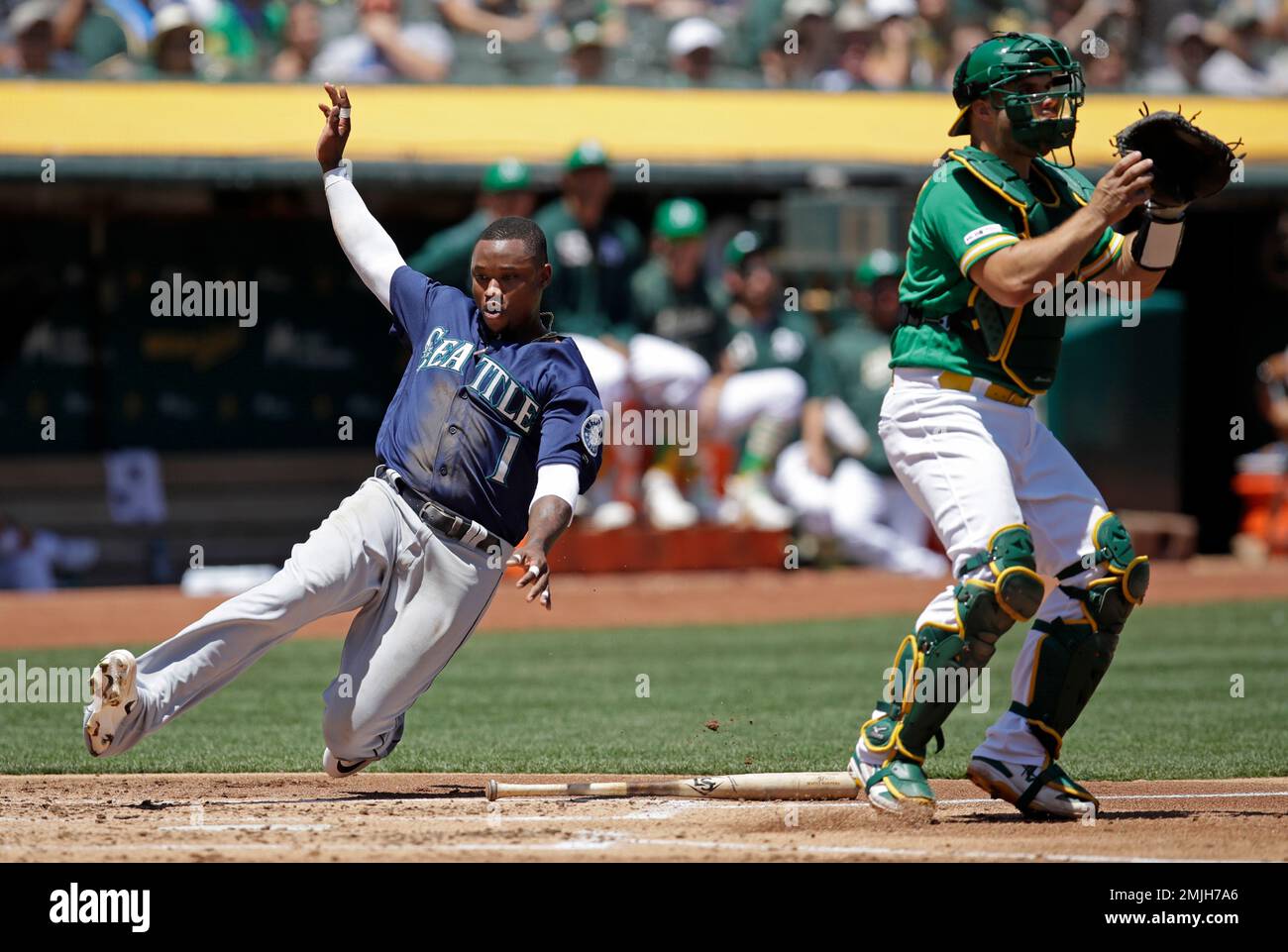 Seattle Mariners' Tim Beckham, left, slides to score behind Oakland ...