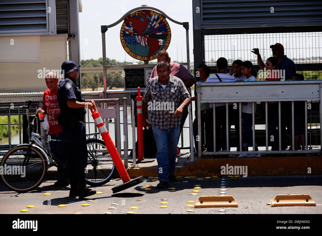 People line up to cross the border into the U.S. on the International ...