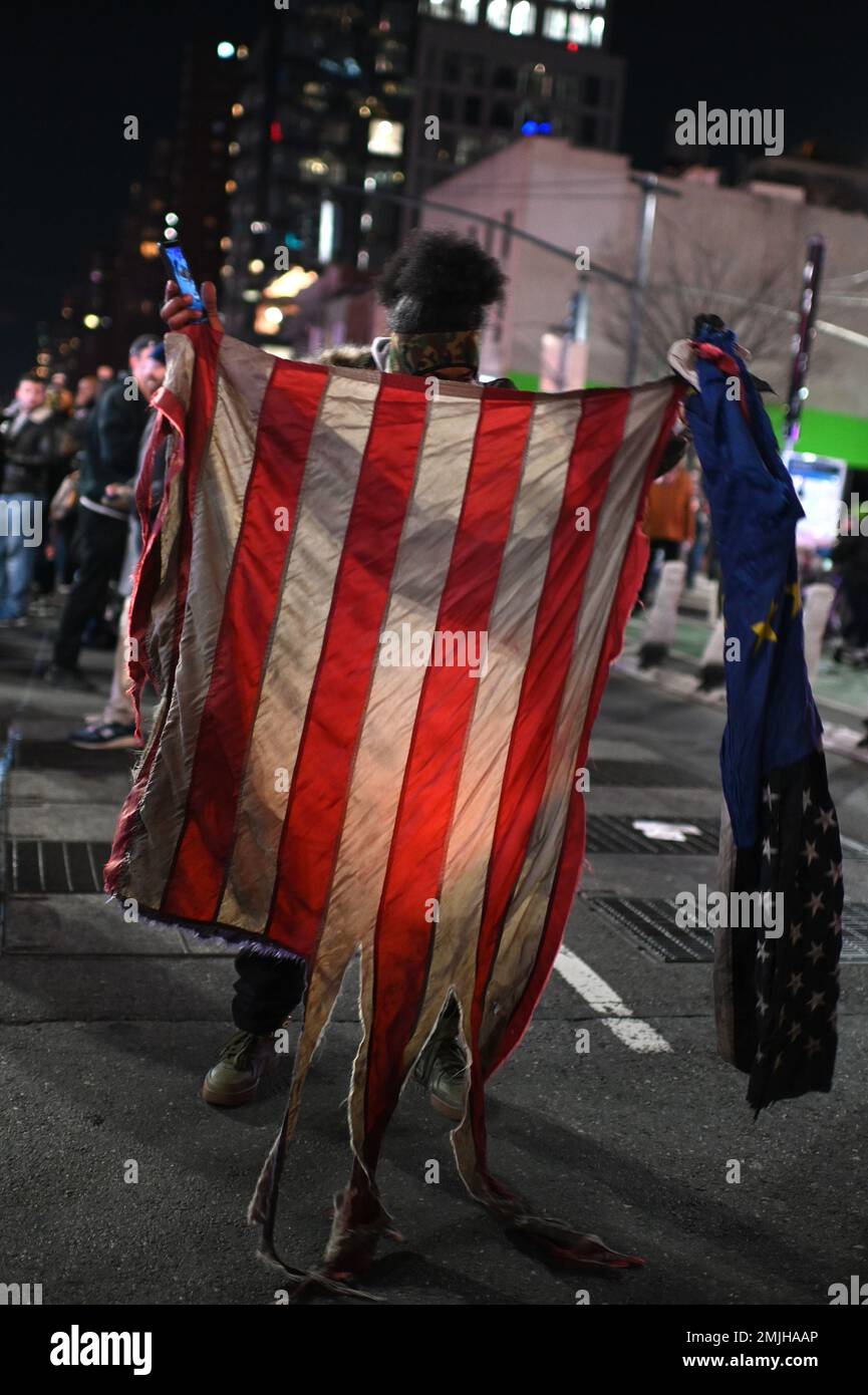 New York, USA. 27th Jan, 2023. A demonstrator holds a tattered America ...