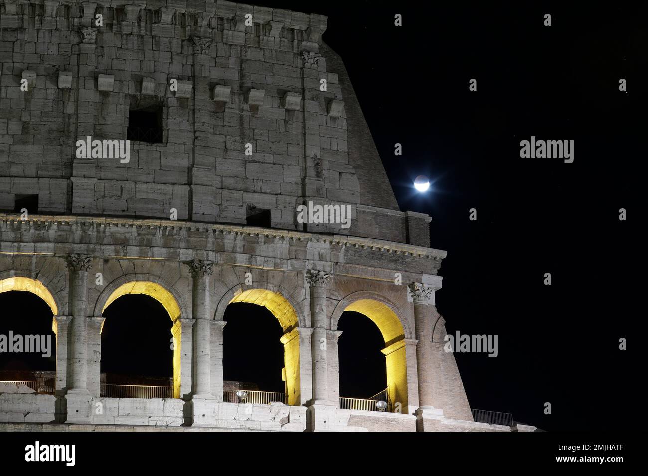 A rising full moon is seen over the Colosseum during a partial lunar ...