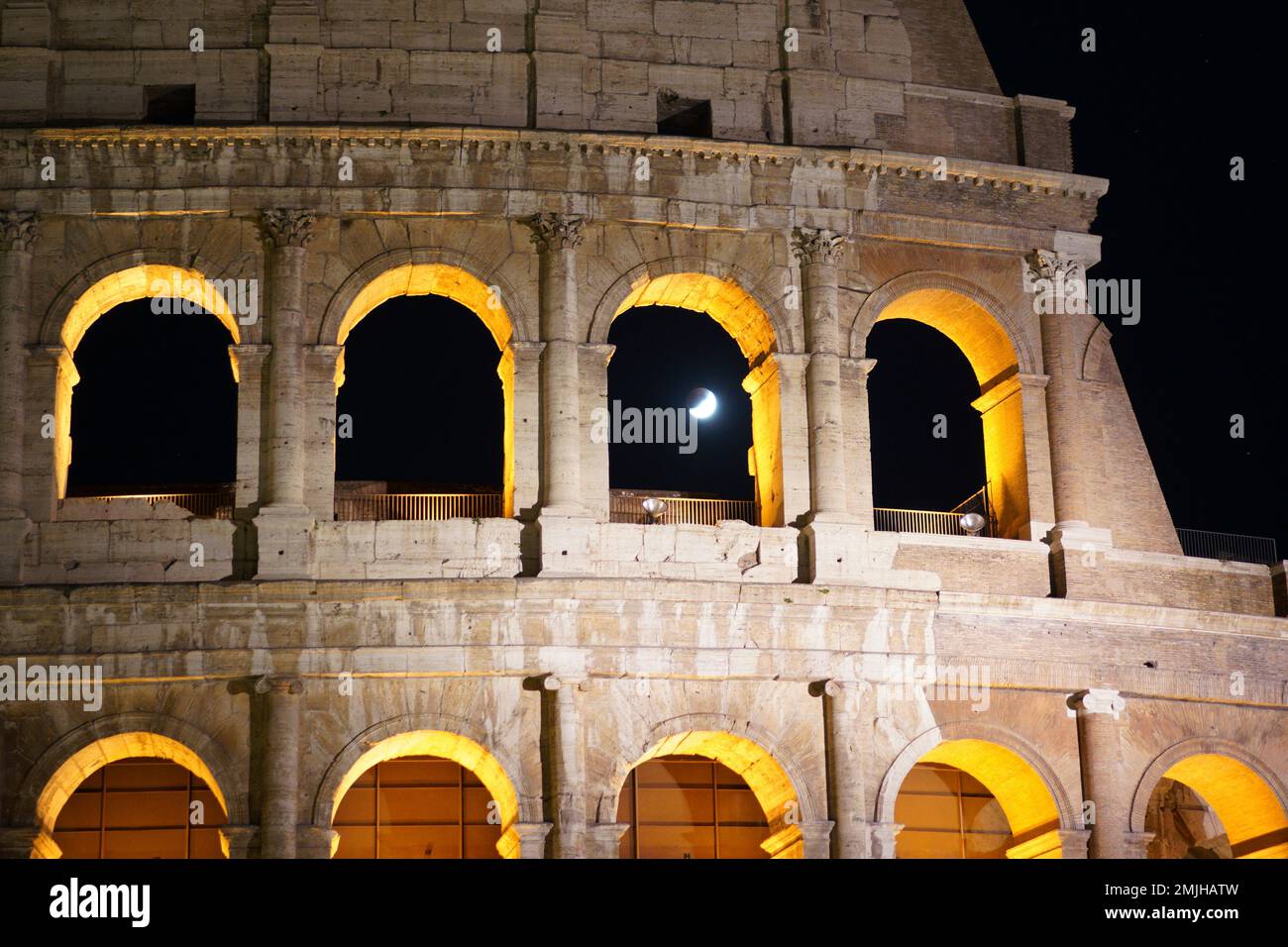 People watch at a rising full moon during a partial lunar eclipse, in ...