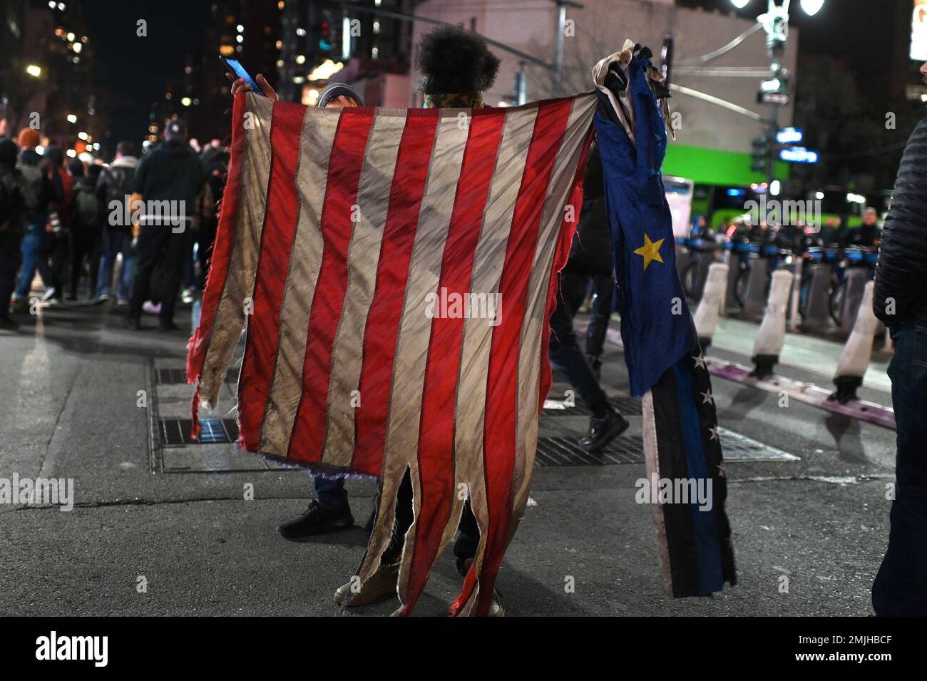 New York, USA. 27th Jan, 2023. A demonstrator holds a tattered America ...