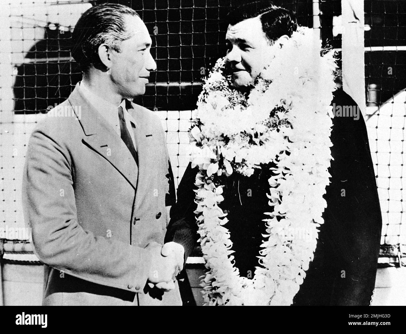 Babe Ruth, smothered in wreaths of flowers with which the Hawaiians ...