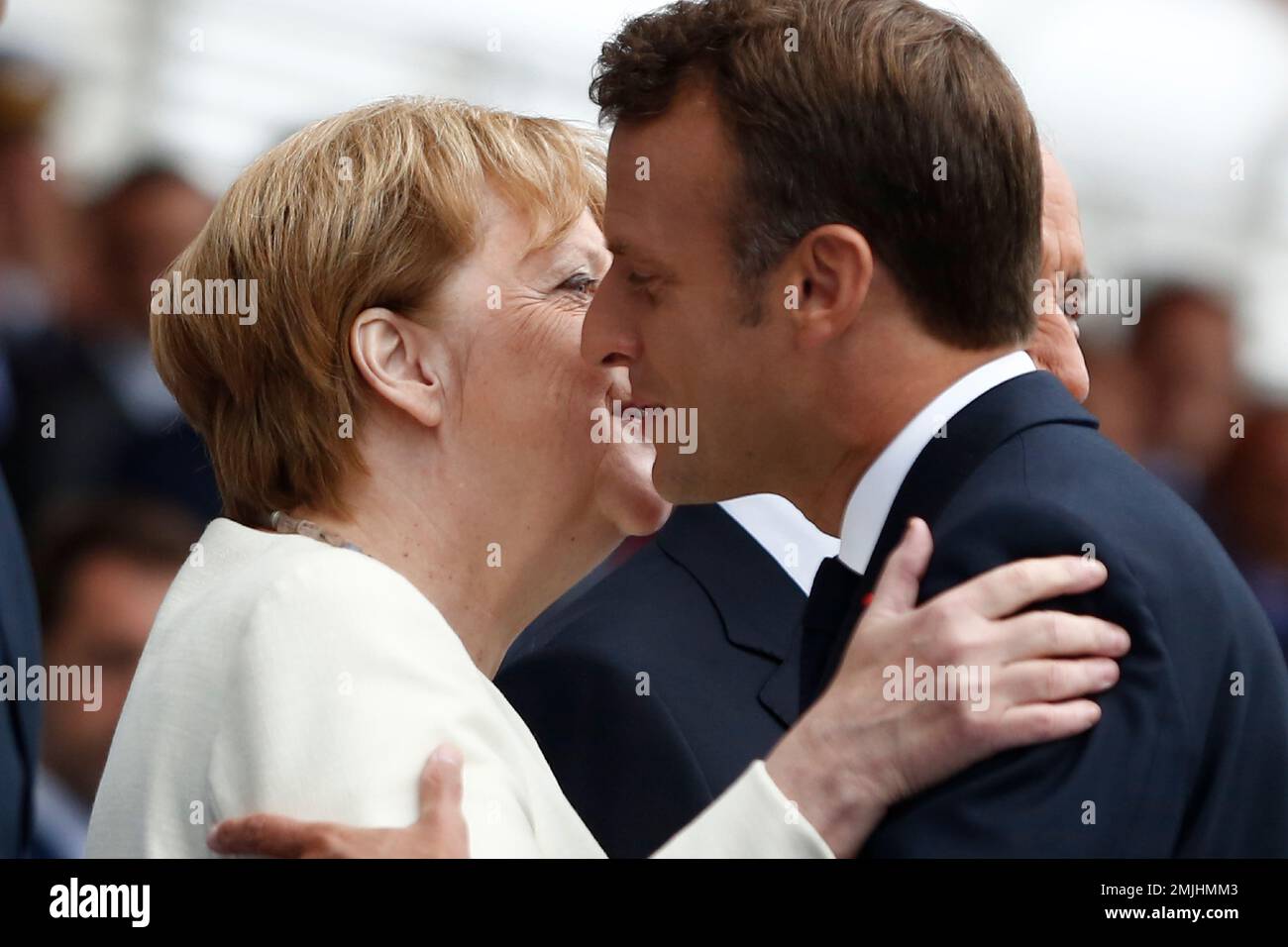 French President Emmanuel Macron, hugs German Chancellor Angela Merkel ...
