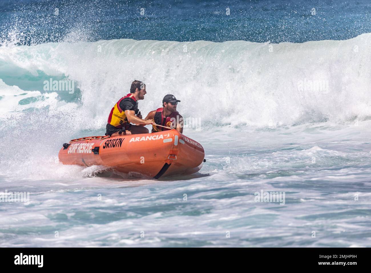 Surf Rescue volunteers power their zodiac RIB dinghy in the ocean off ...