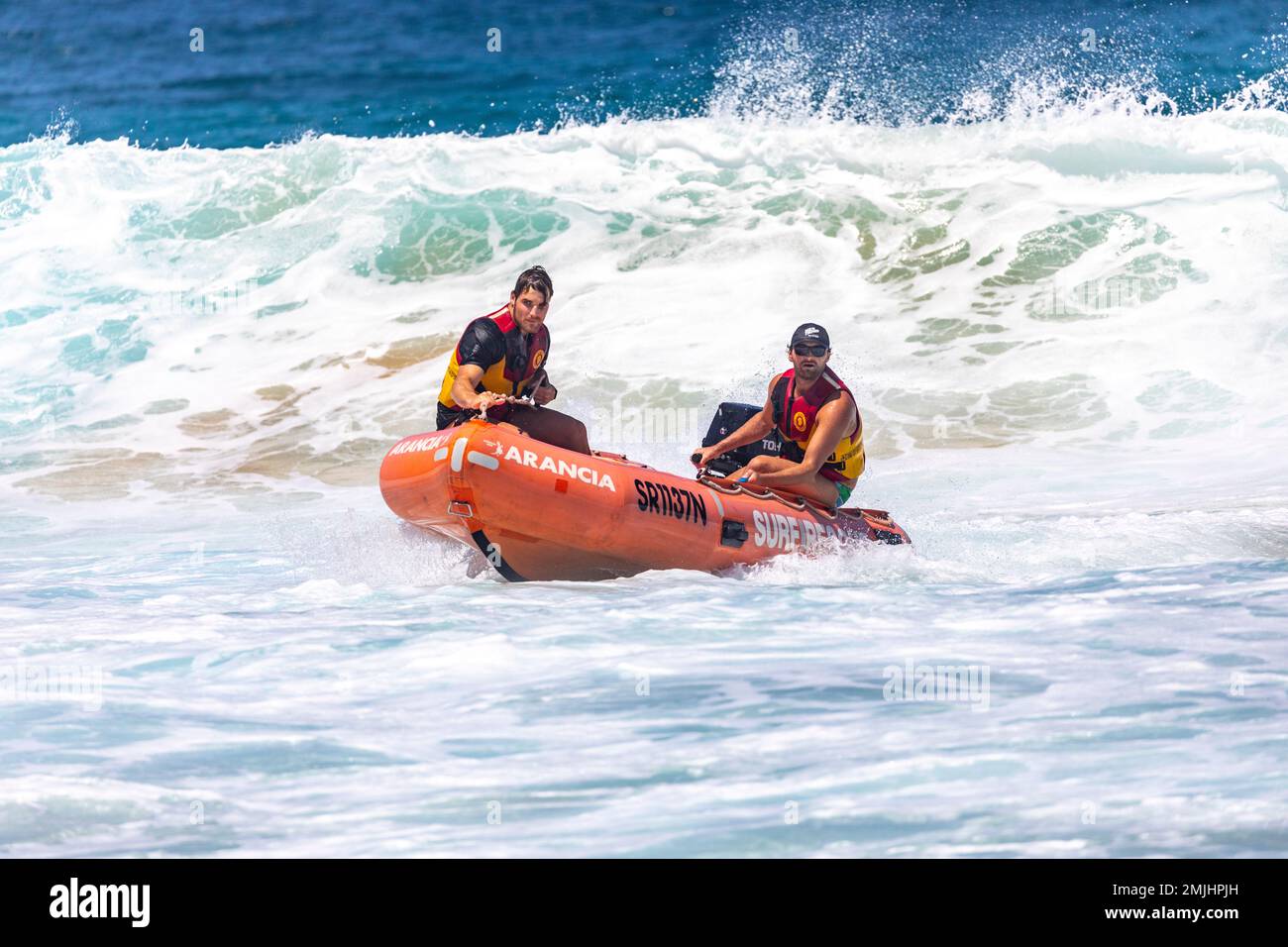 Surf Rescue volunteers power their zodiac RIB dinghy in the ocean off ...