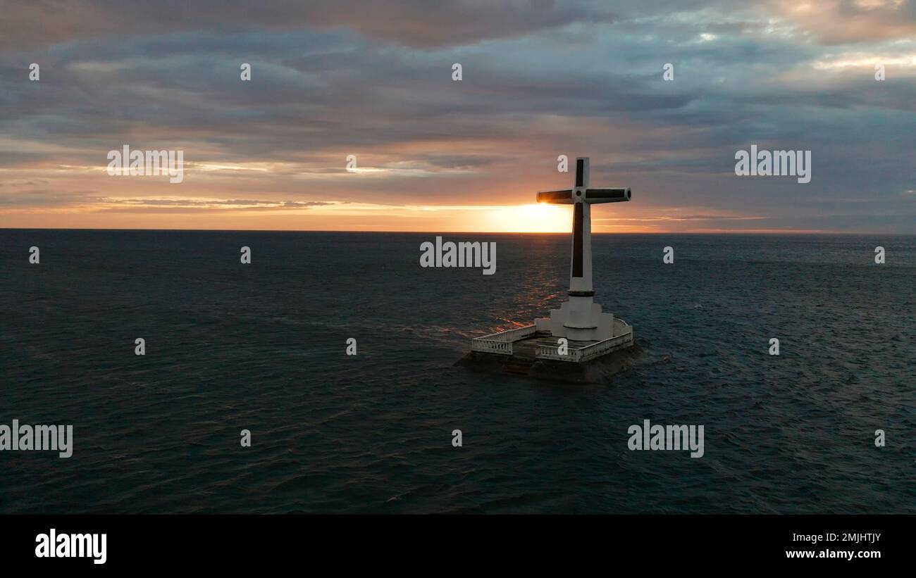 Catholic cross in sunken cemetery in the sea at sunset, aerial view ...