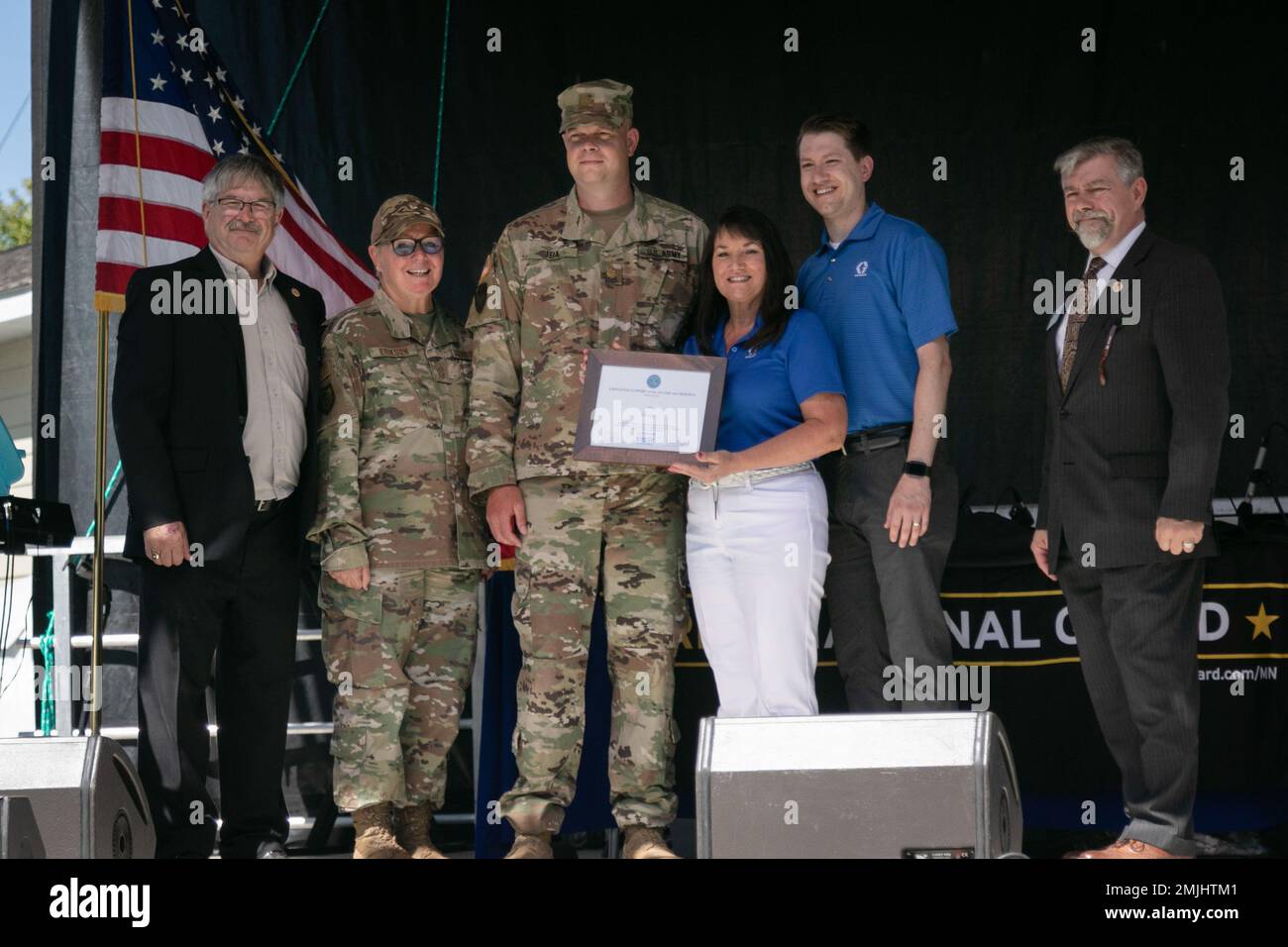 Minnesota National Guard Soldier, Maj. Adam Feia stands with his supervisor, Kellie, to recieve ...