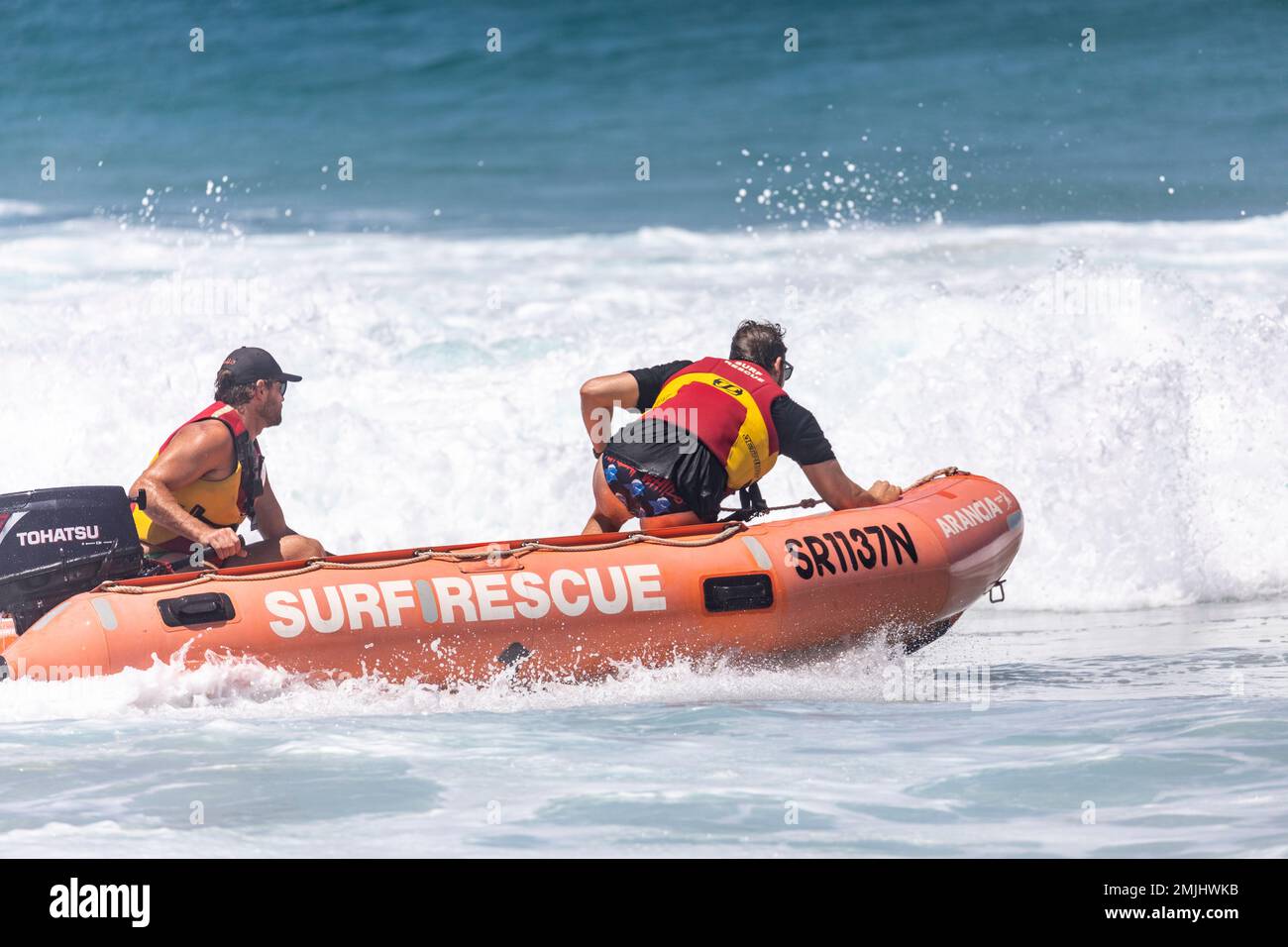 Surf Rescue volunteers power their zodiac RIB dinghy in the ocean off ...