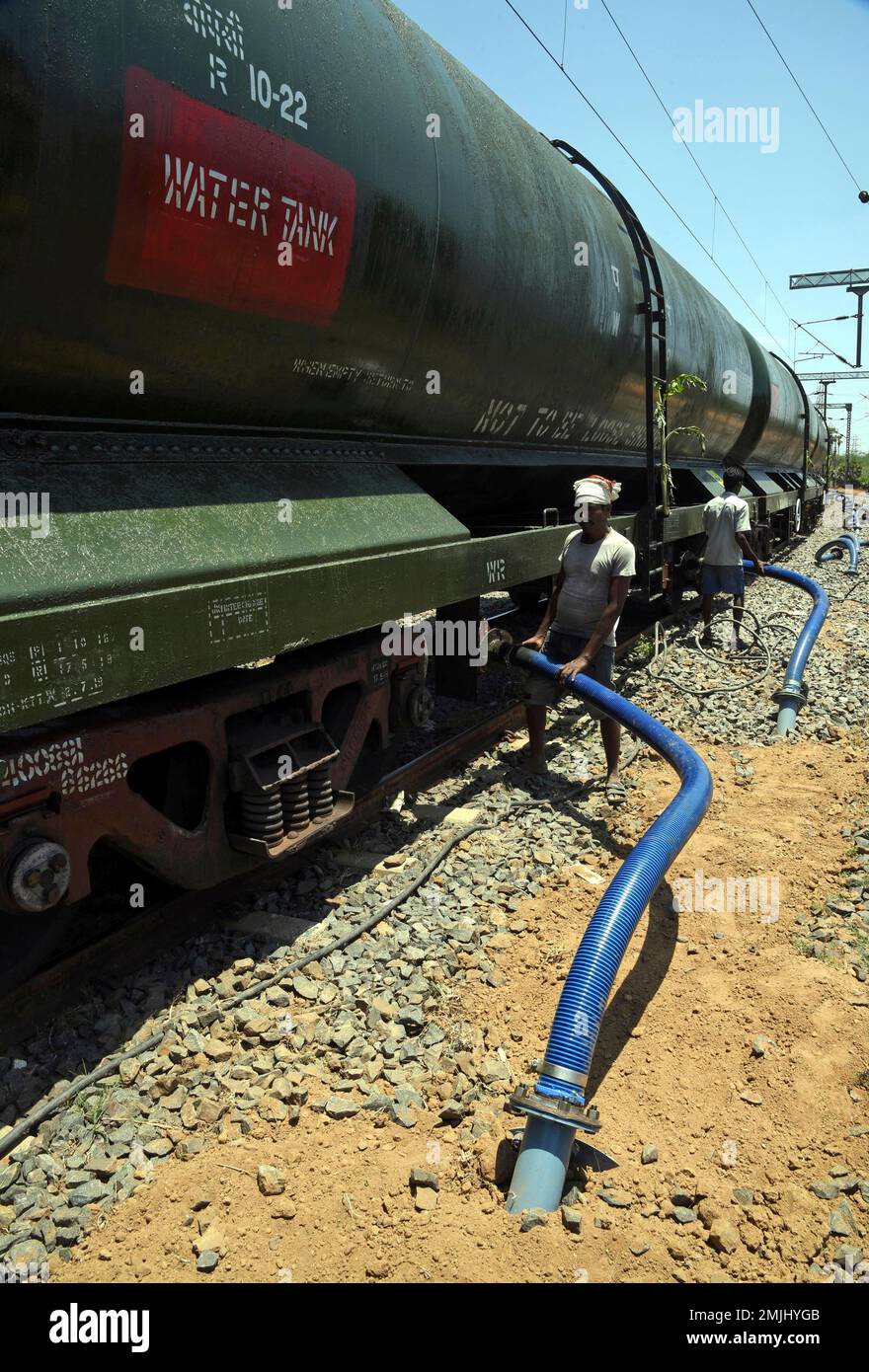 Laborers stand by inlet pipes discharging water from a train at the ...