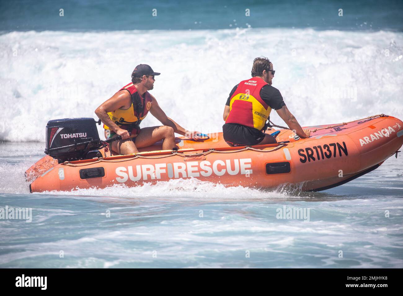 Surf Rescue volunteers power their zodiac RIB dinghy in the ocean off ...