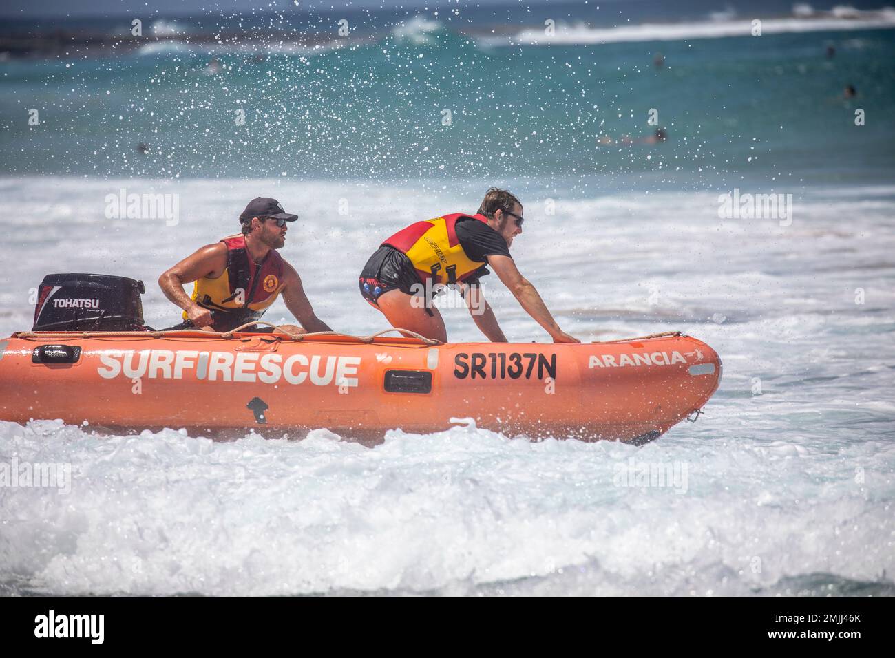 Surf Rescue volunteers power their zodiac RIB dinghy in the ocean off ...